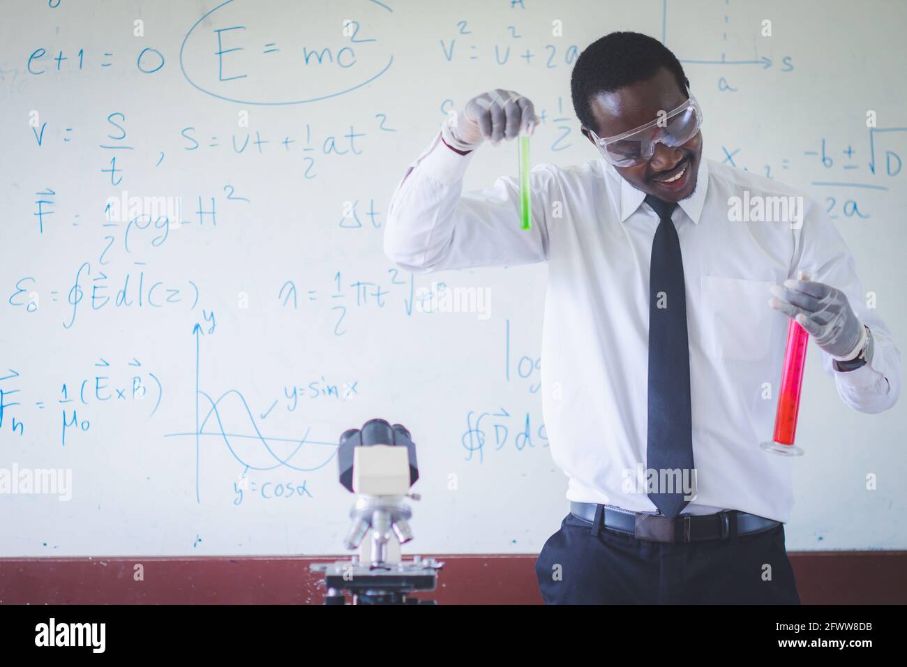 African teacher is doing science experiments inside the classroom with ...