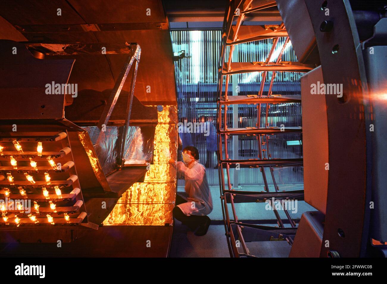 A thin film coating chamber with a technician. A worker prepares a ...