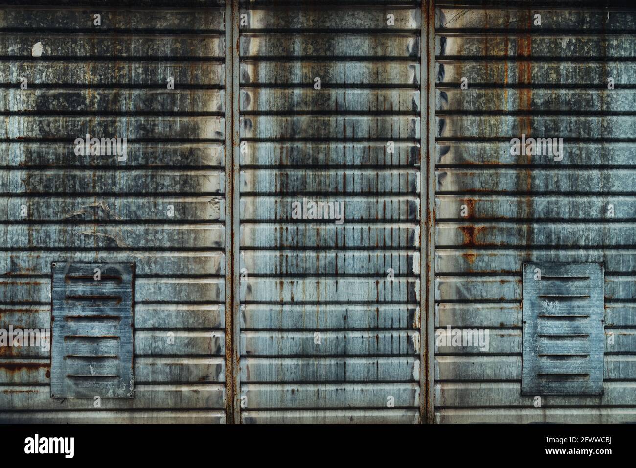 Worn corrugated steel plate garage wall as background, corroded and ...
