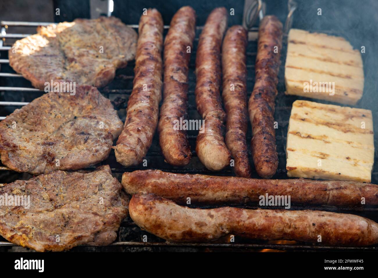 german sausages, pork steaks and grilled cheese on a grill Stock Photo ...