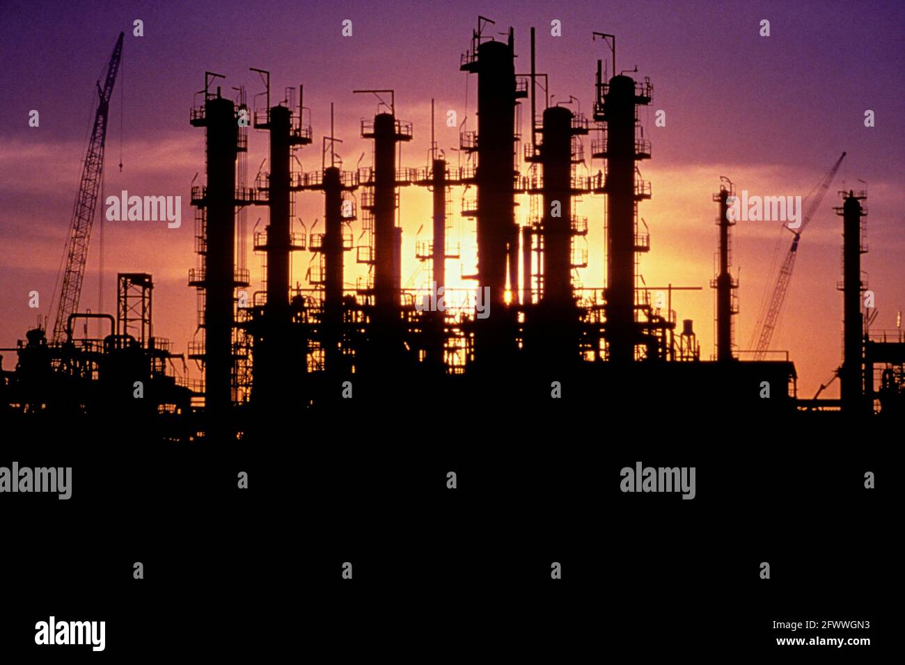 A refinery backlit at sunset Stock Photo - Alamy