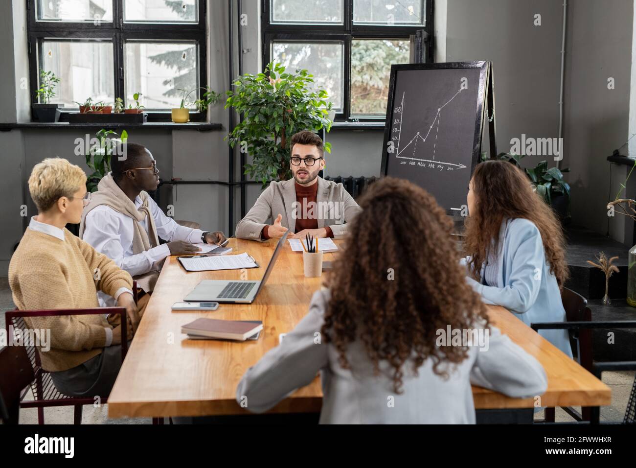 Financial managers sitting by table during discussion of working points ...