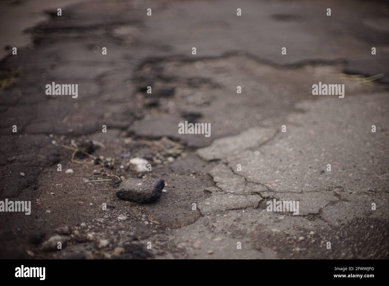 Closeup view of an old broken asphalt road Stock Photo - Alamy