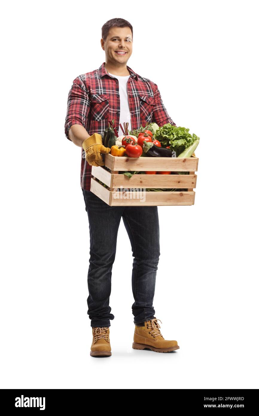 Young man carrying a crate with vegetables isolated on white background ...