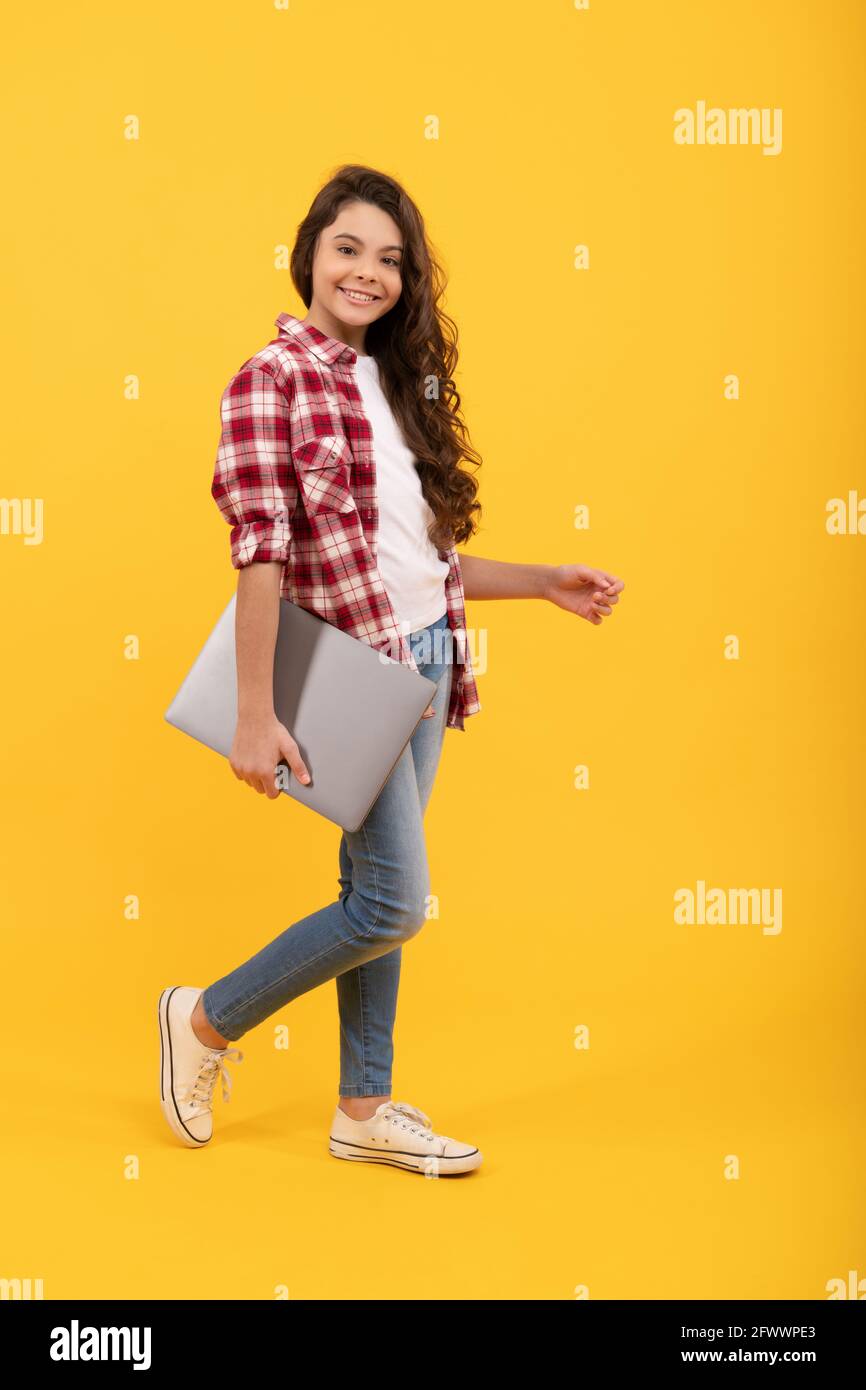 Happy kid back to school carrying laptop digital device learning ...