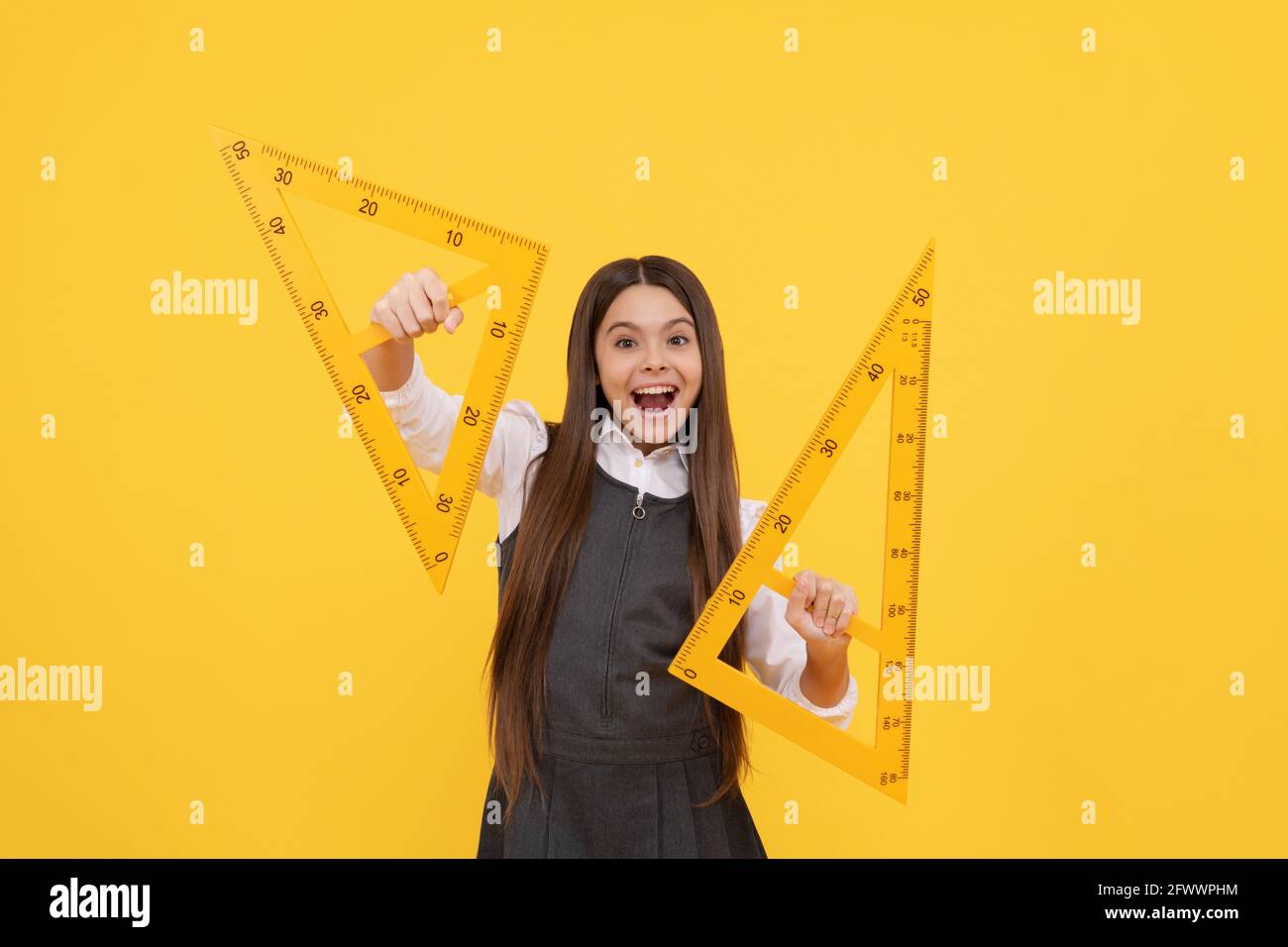 happy child hold math triangle ruler in school on yellow background ...