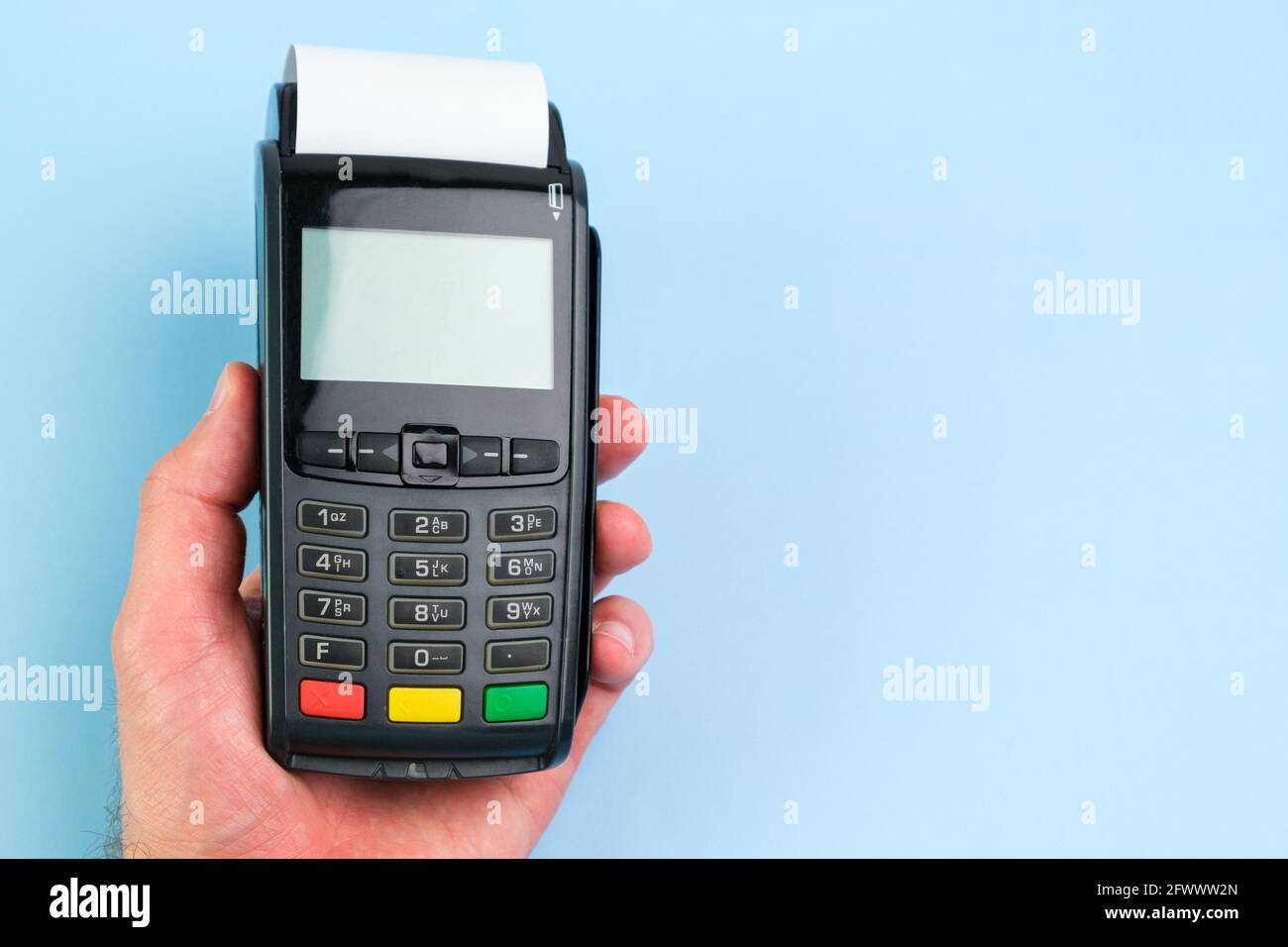 Man hand pushing a button on POS terminal with roll paper cash tape on ...