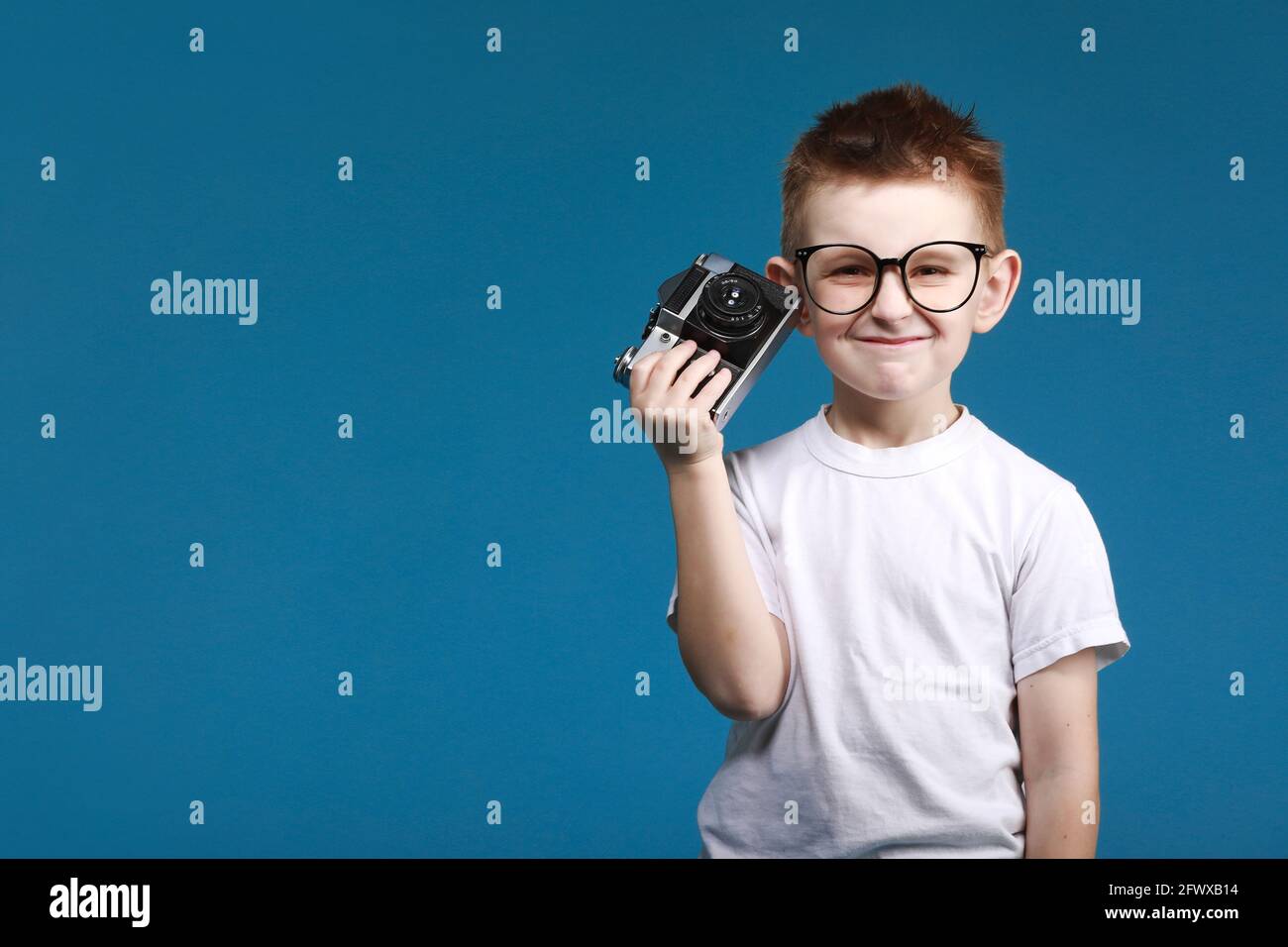 Little boy taking a picture using a retro camera. Child boy with ...