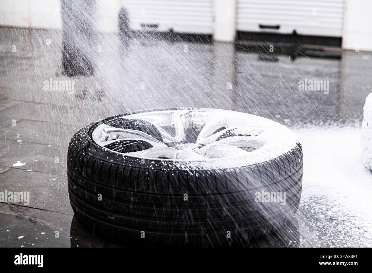 Cleaning car wheel and tire with active foam Stock Photo - Alamy