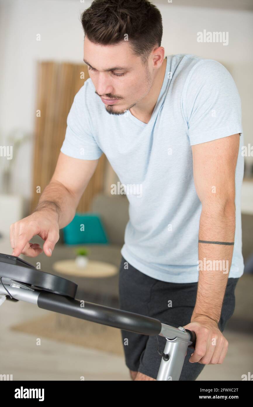 young adult man setting control panel of treadmill before running Stock ...