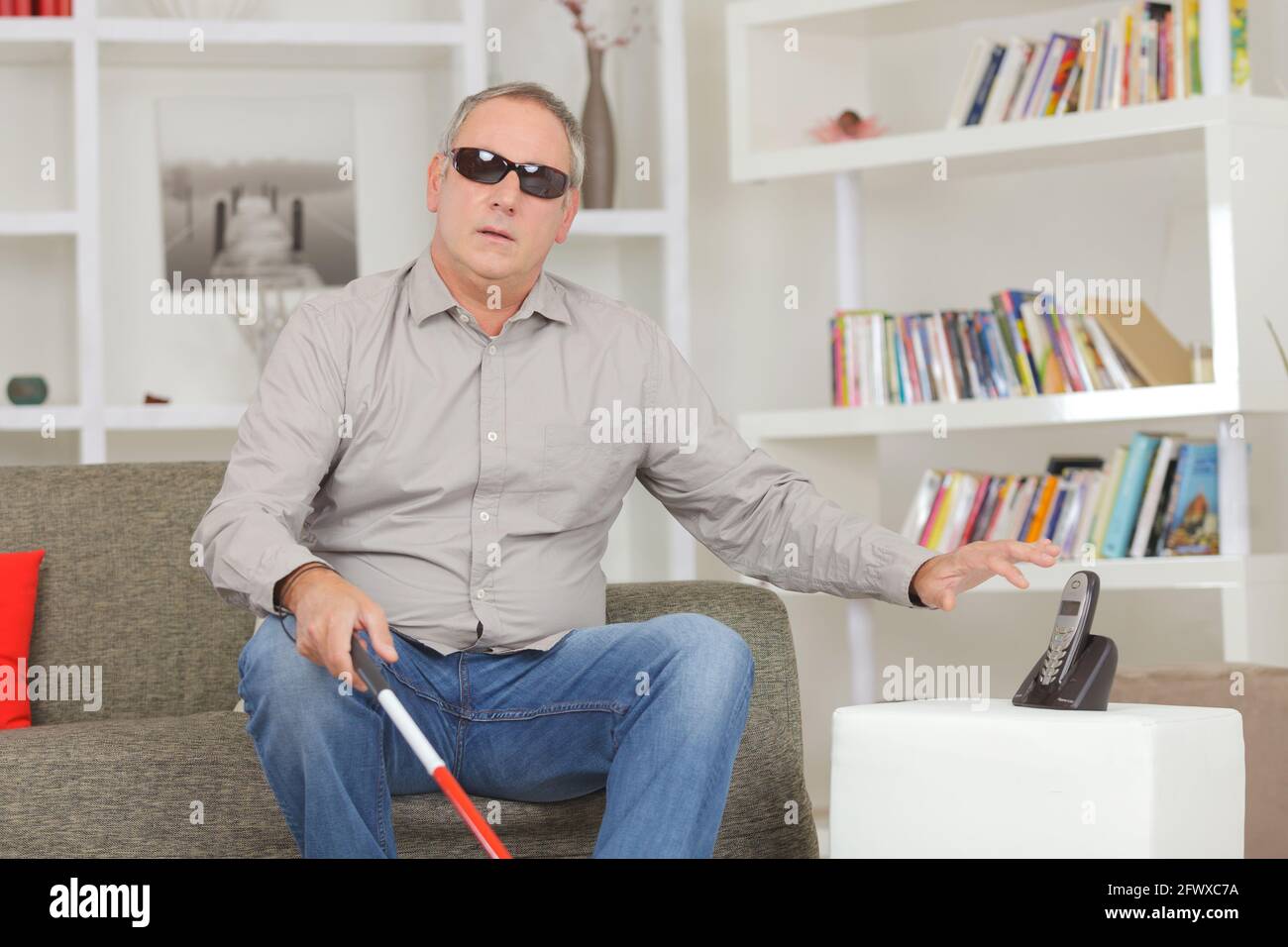 blind man at home reaching for the telephone Stock Photo - Alamy
