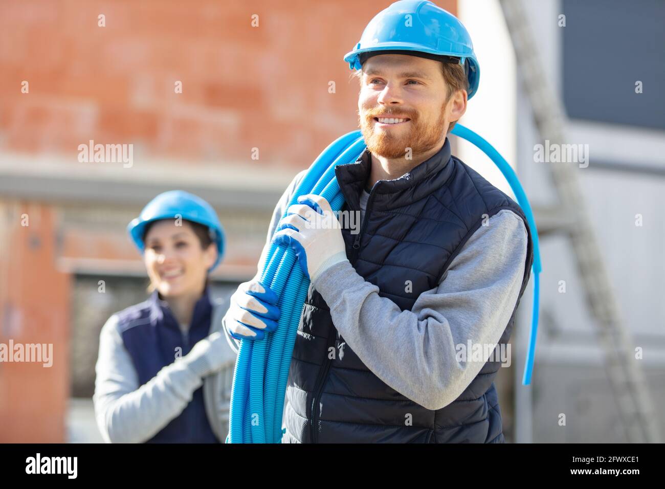 construction worker on site holding pipe Stock Photo - Alamy
