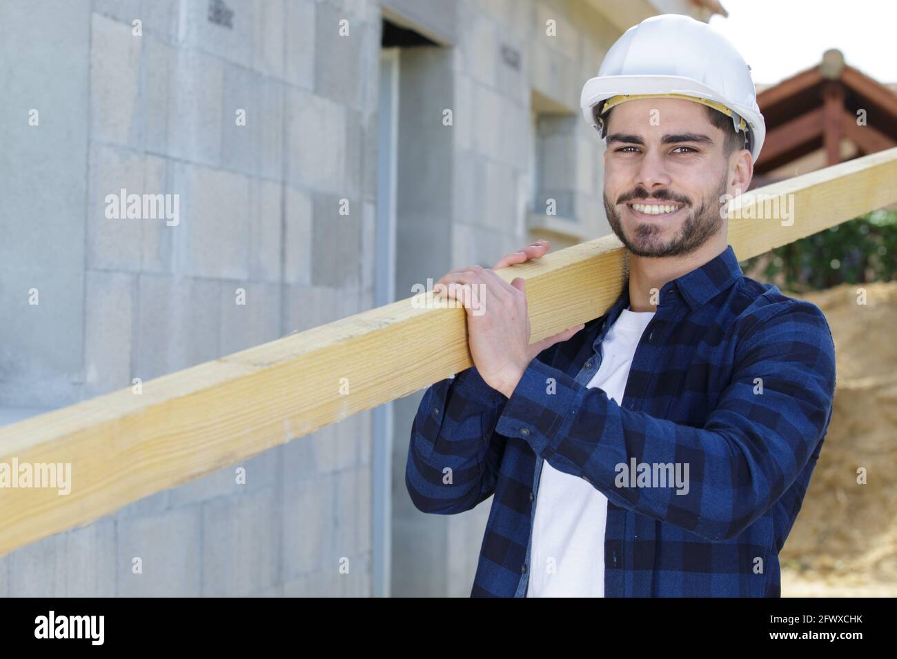 man as builder carrying wood and working Stock Photo - Alamy