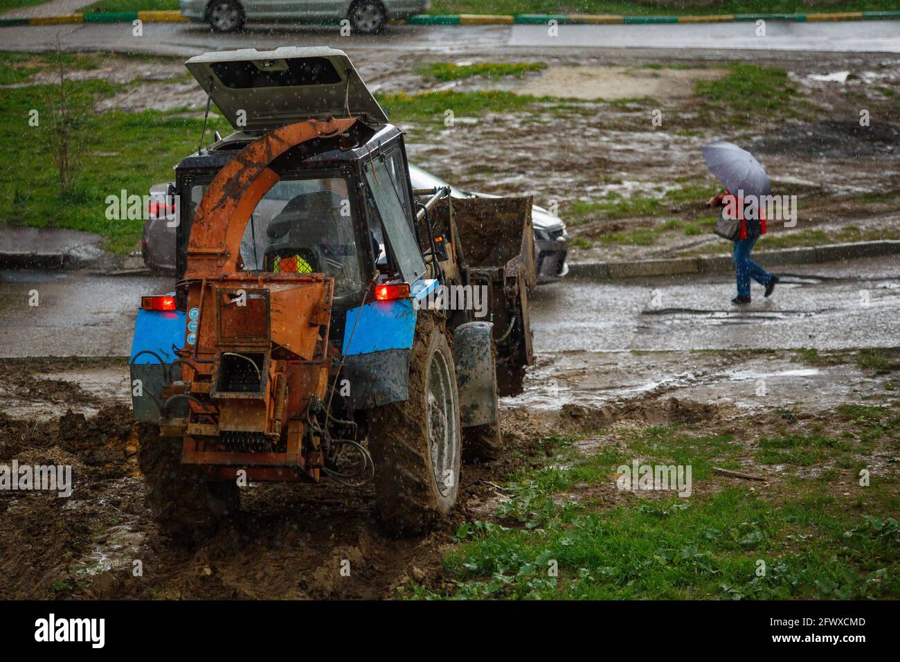 old tractor at rainy day making dirt job on lawn near road Stock Photo ...