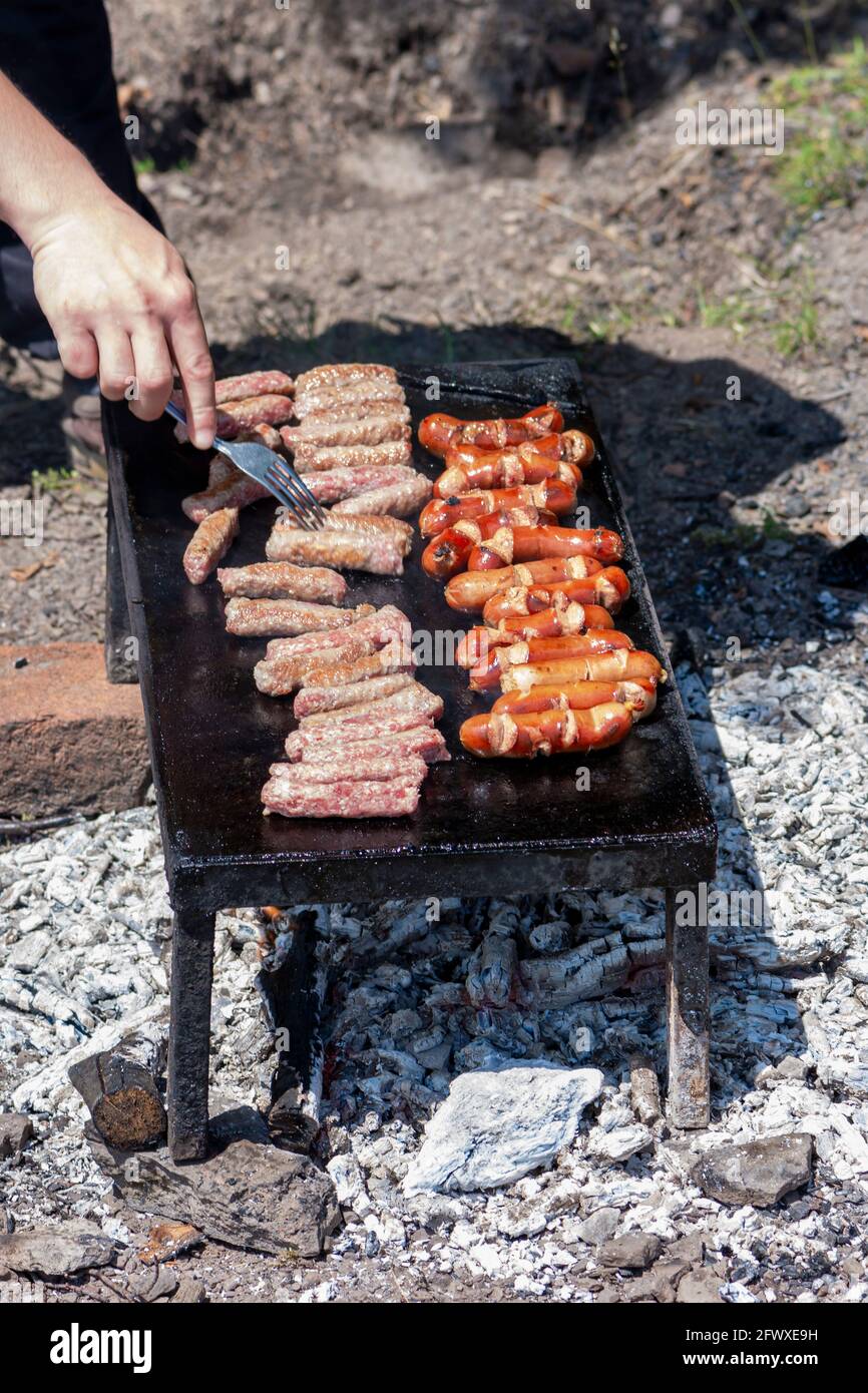 Male hand turning delicious grilled meat by fork Stock Photo - Alamy