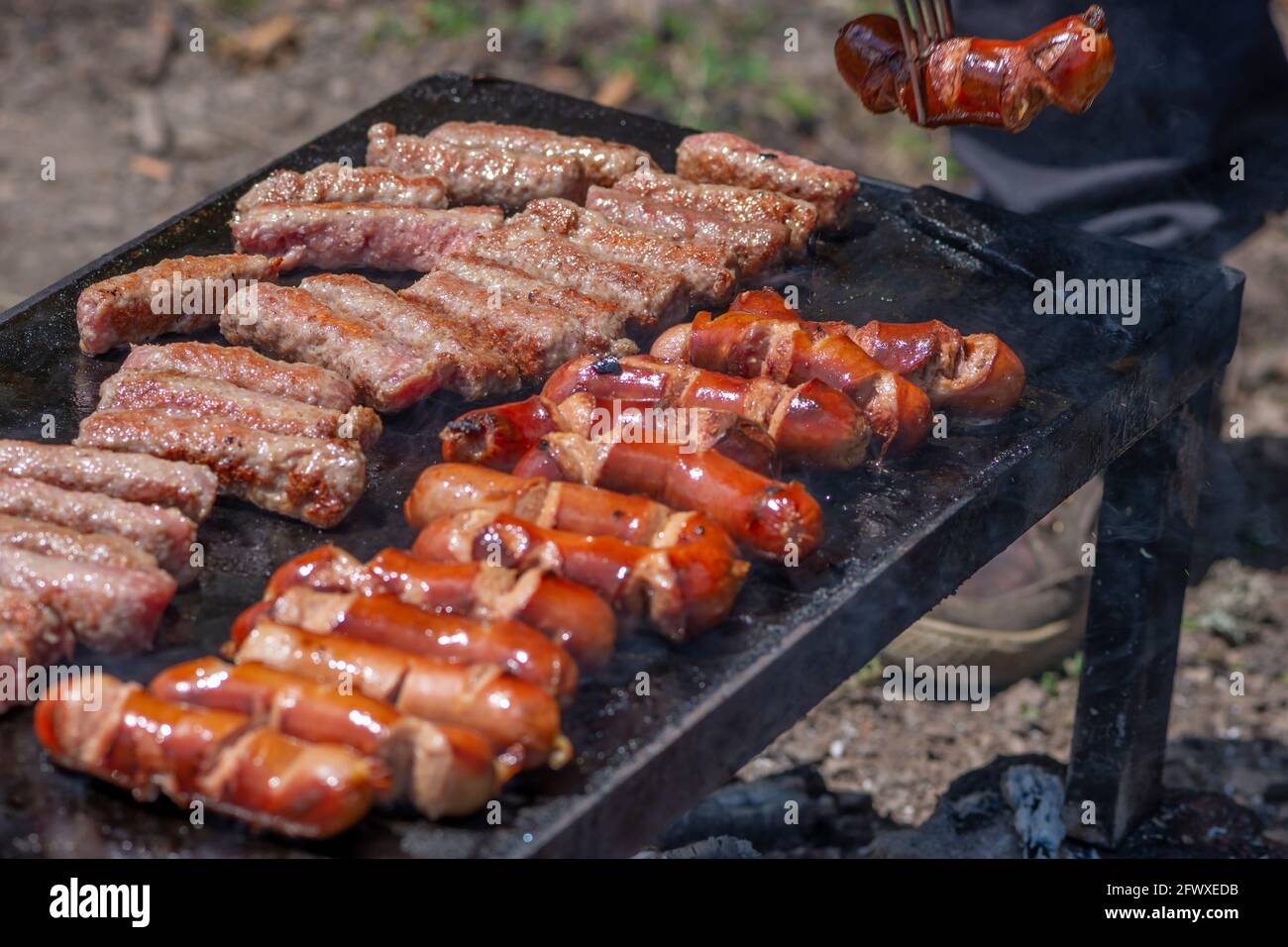 Male hand turning delicious grilled meat by fork Stock Photo - Alamy