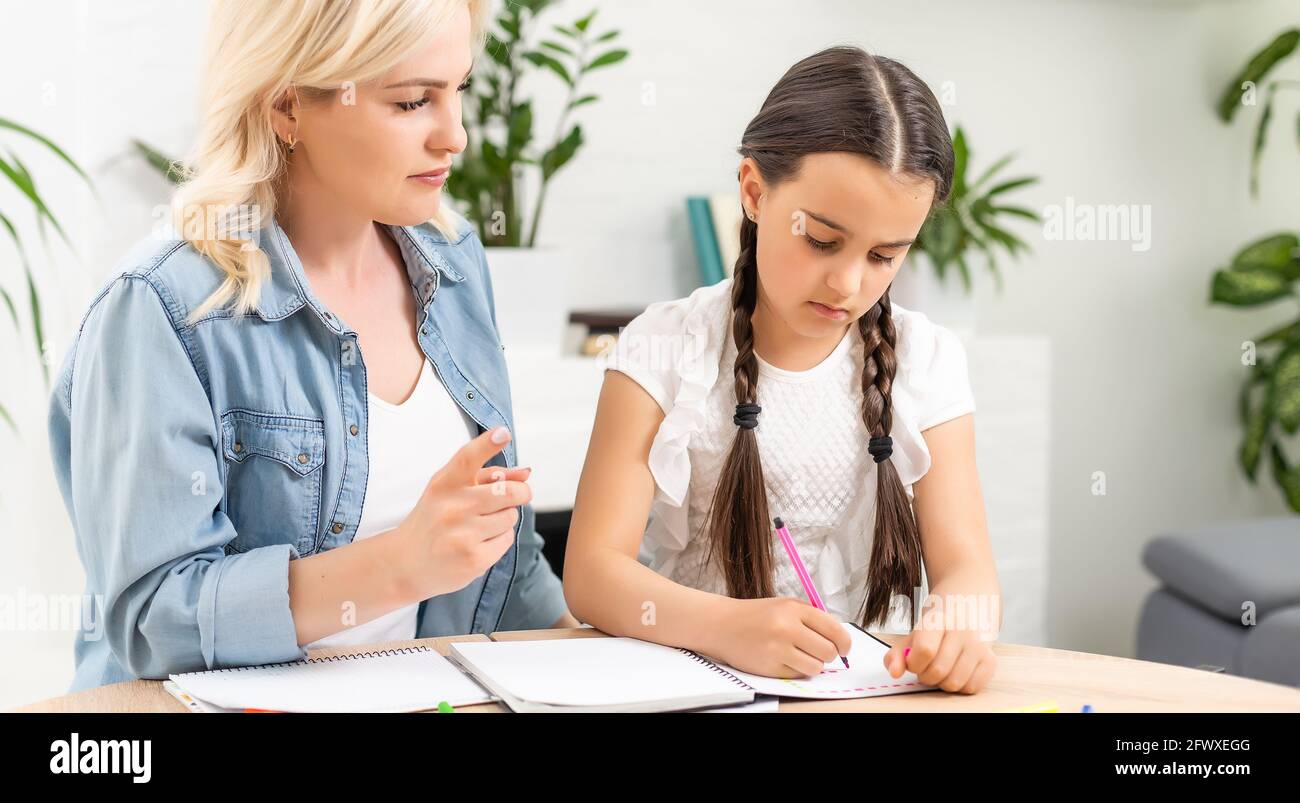 Mom helping her daughter do homework Stock Photo - Alamy