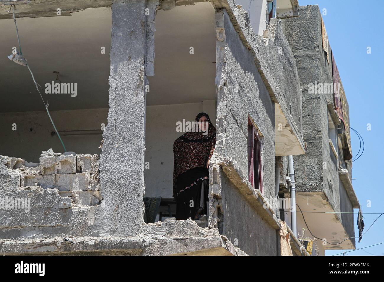 Gaza. 24th May, 2021. A Palestinian woman is seen at a destroyed house ...