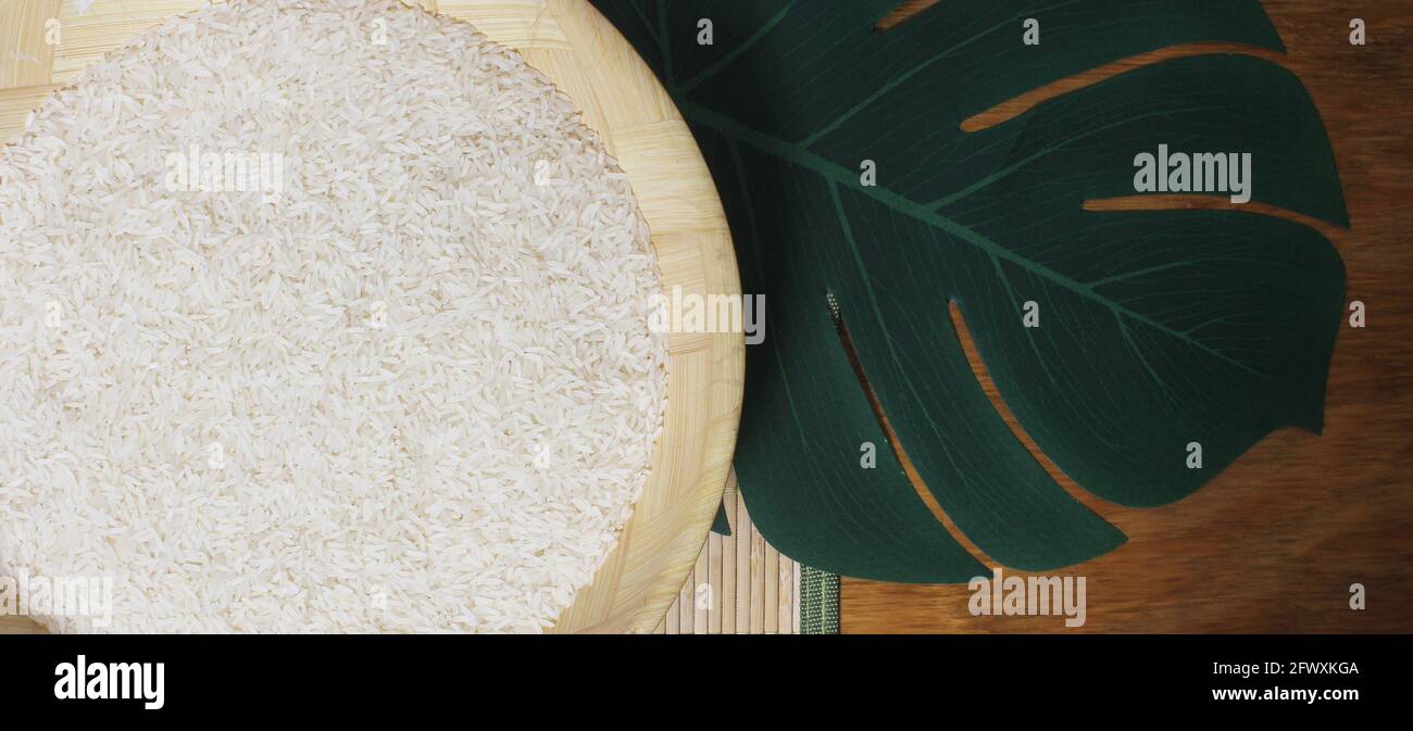 Bowl of Uncooked White Rice with leaf on bamboo mat Stock Photo - Alamy
