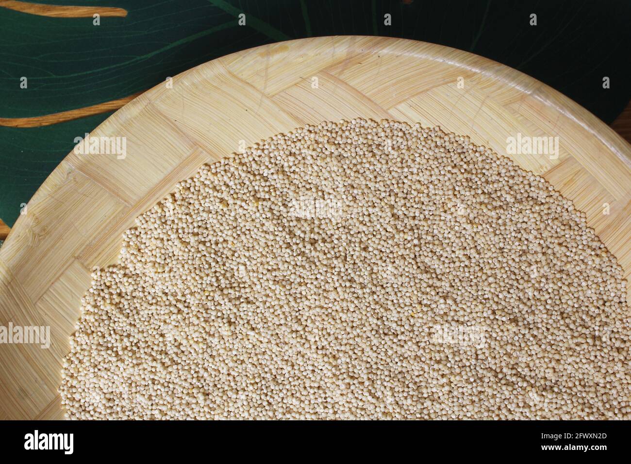 Bowl of Uncooked Millet with leaf on bamboo mat Stock Photo - Alamy