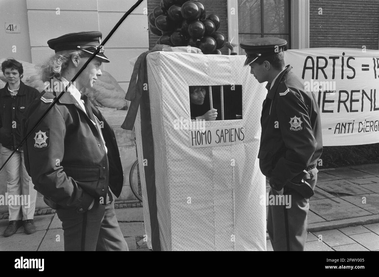 Protest against Artis zoo; a Homo Sapiens in cage is viewed by officers ...