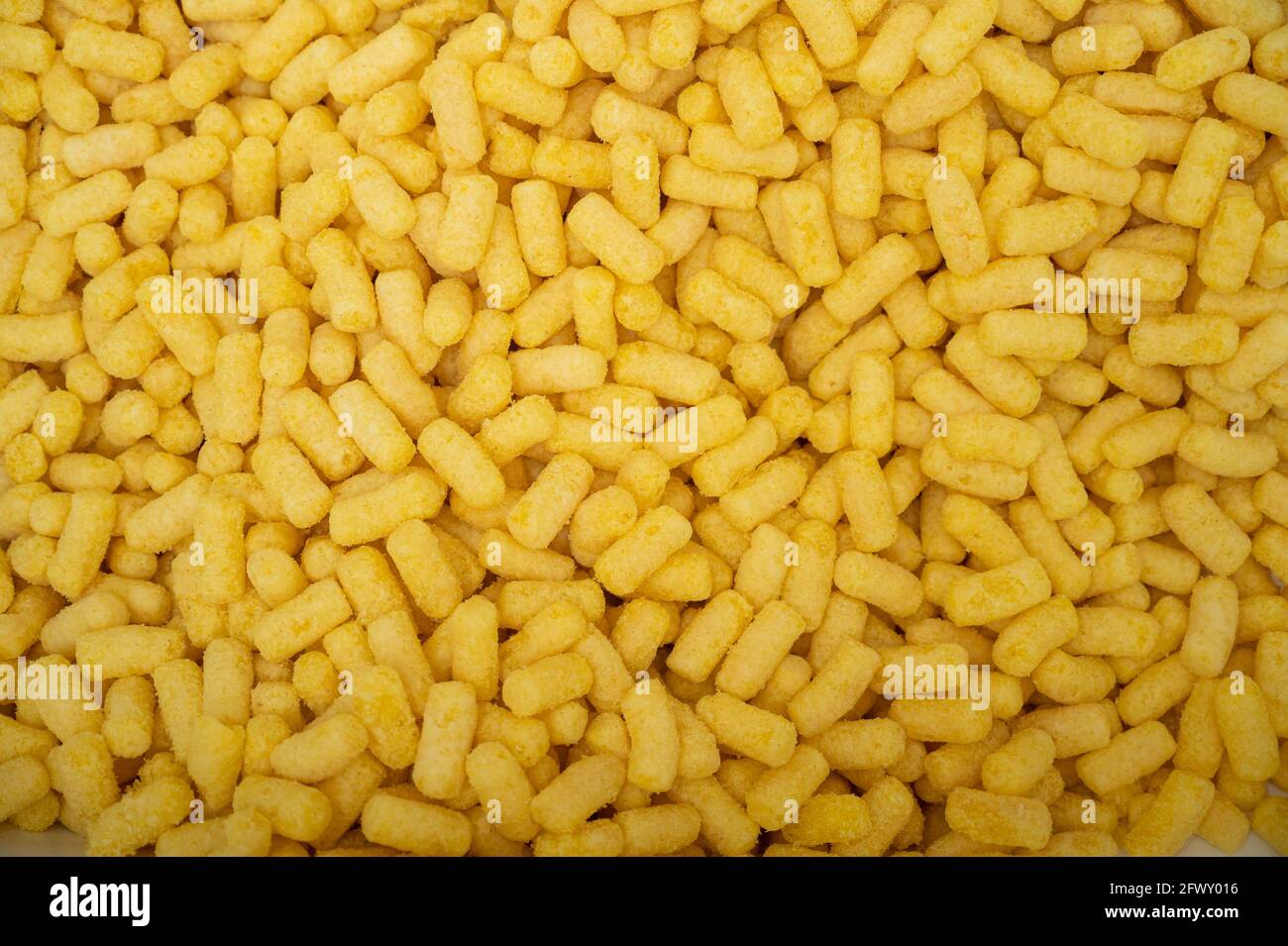 Yellow corn sticks close-up. Background of corn sticks. Harmful sweet ...