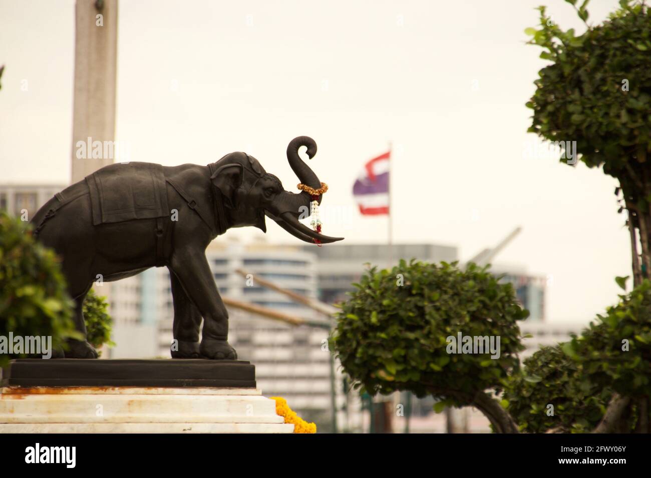 A stone-made statue of an elephant and a Thai flag at the palace in ...