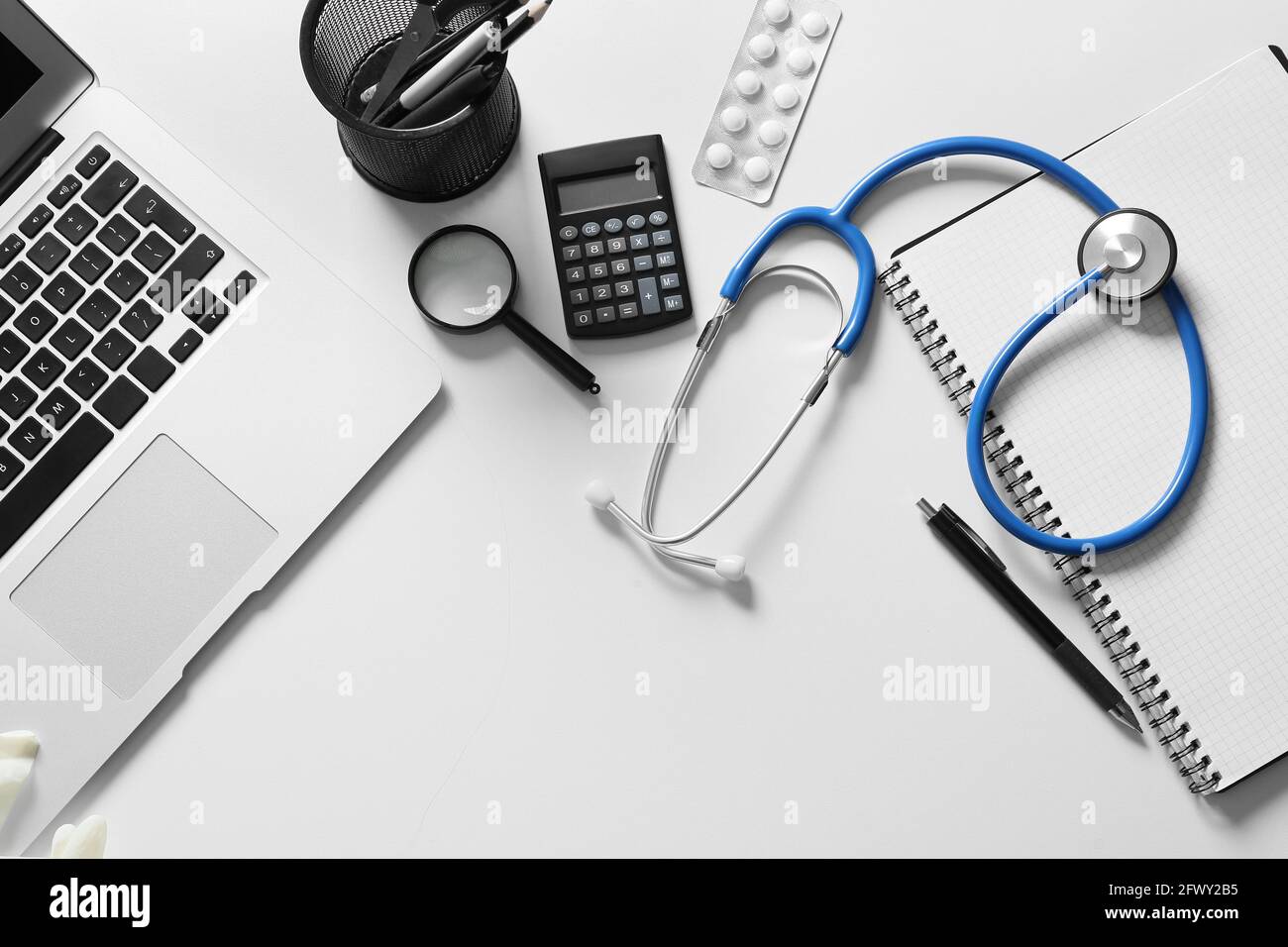 Composition with modern stethoscope and laptop on light background ...