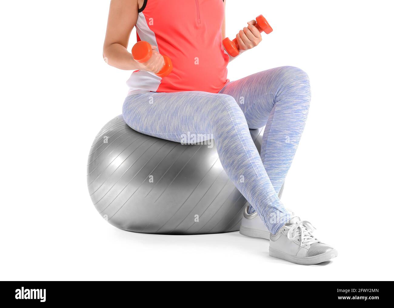 Pregnant woman with dumbbells and fitball training on white background ...