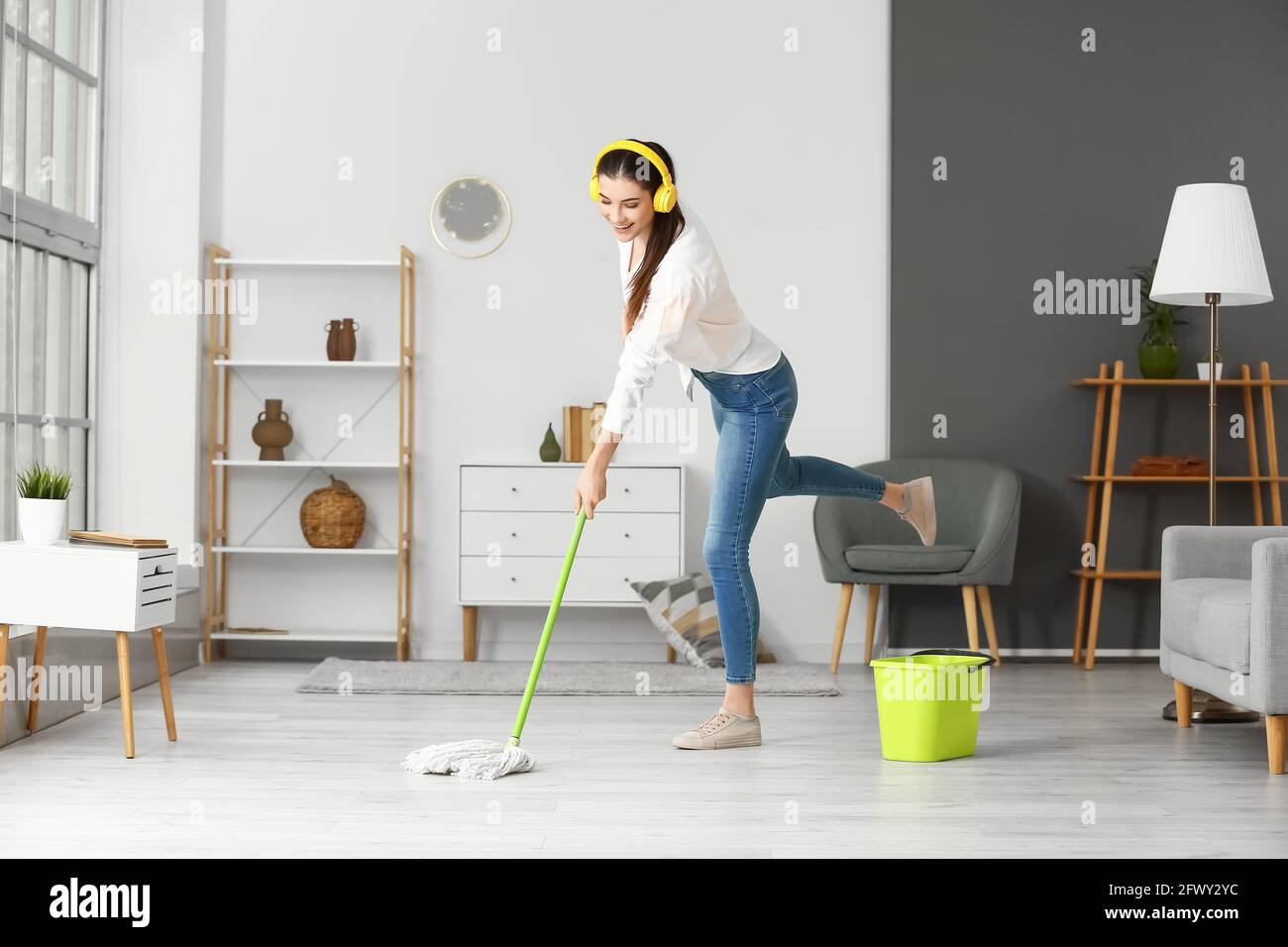 Young woman having fun while mopping floor in her flat Stock Photo - Alamy