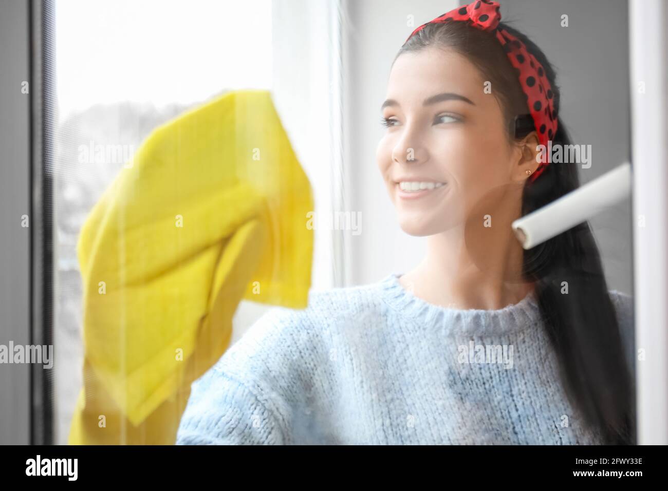 Young woman cleaning window in her flat Stock Photo - Alamy