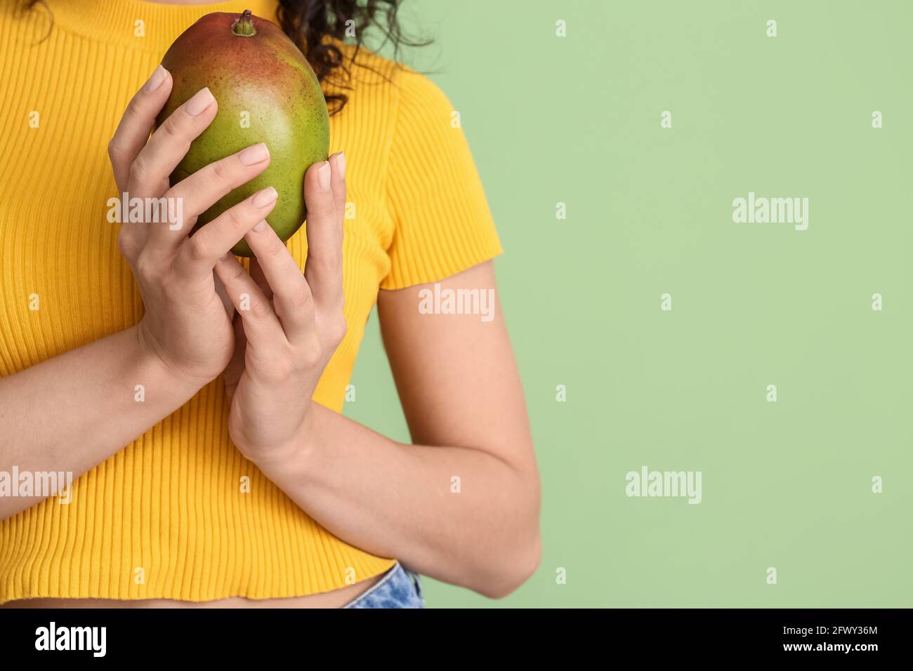 Beautiful woman with fresh mango on color background Stock Photo - Alamy
