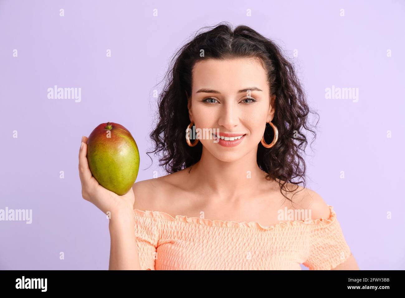 Beautiful woman with fresh mango on color background Stock Photo - Alamy