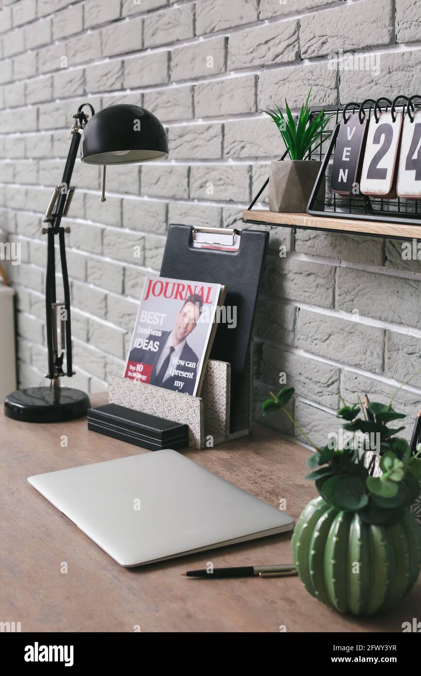 Modern workplace with laptop and organizer near brick wall Stock Photo ...
