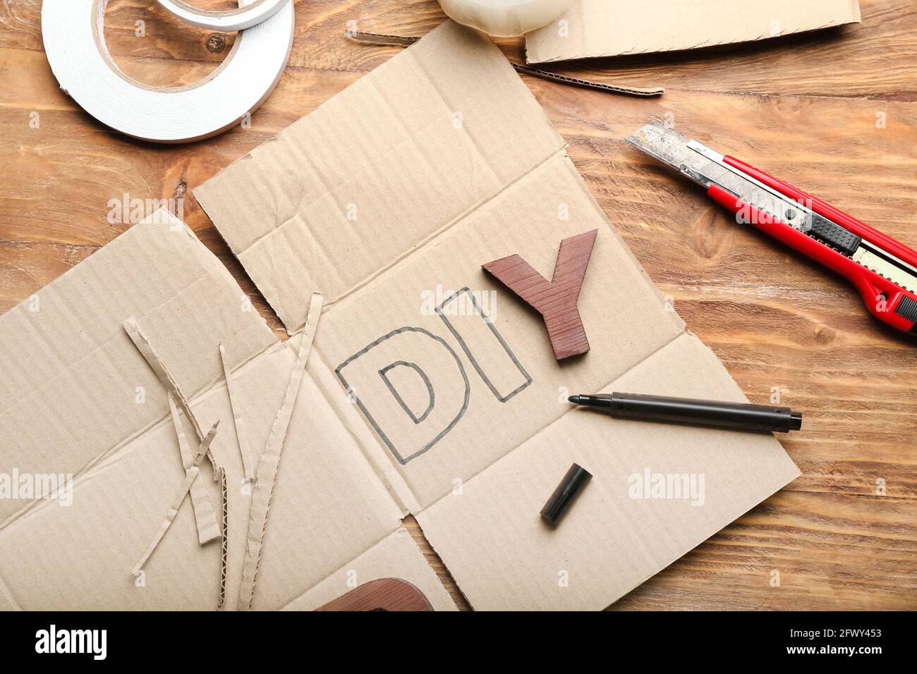 Word DIY, cardboard and knife on wooden background Stock Photo - Alamy