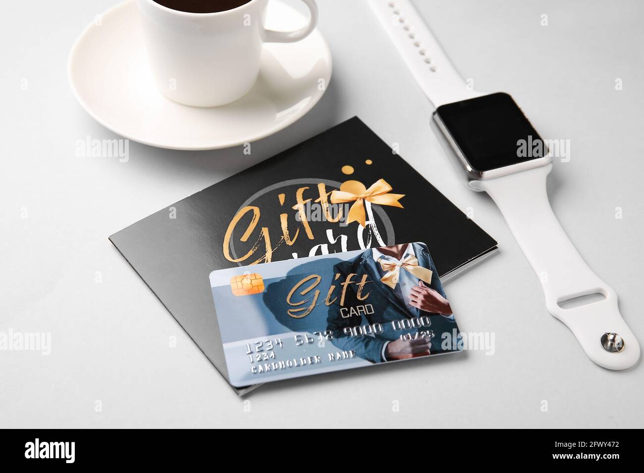 Gift card and smartwatch on light background Stock Photo - Alamy