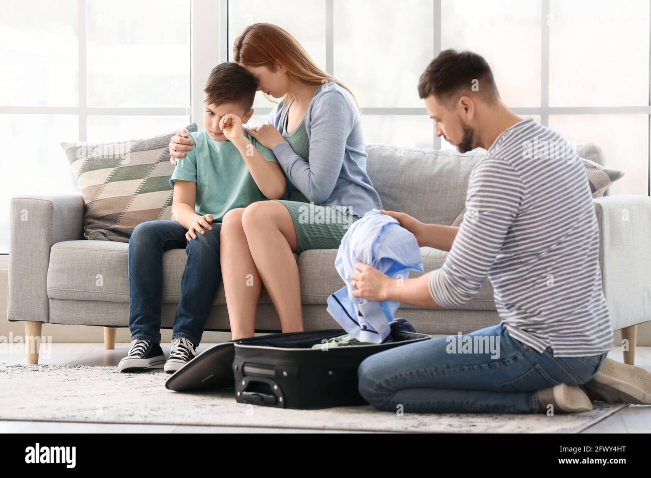 Man packing his belongings and sad woman with little boy at home Stock ...