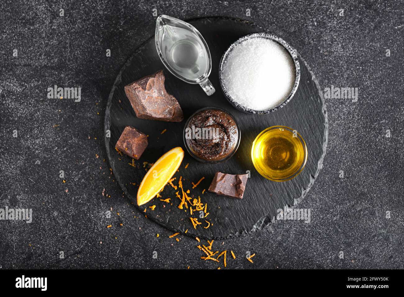Composition with chocolate body scrub and ingredients on dark ...