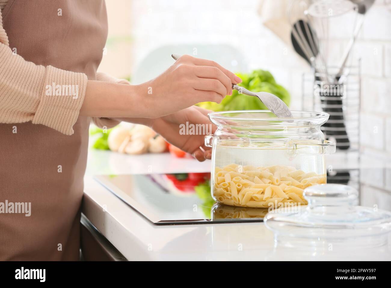 Woman cooking pasta in kitchen Stock Photo - Alamy