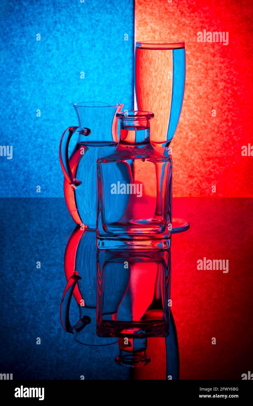 Still life with glass objects on a colored background Stock Photo - Alamy