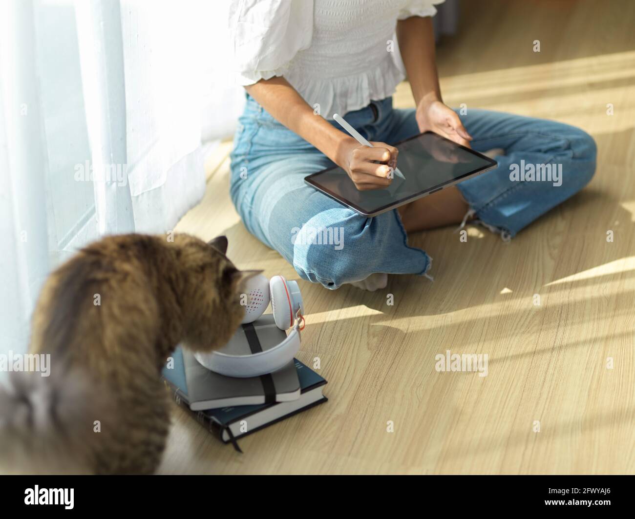 Cropped shot of female using tablet on her lap while crossed legs ...