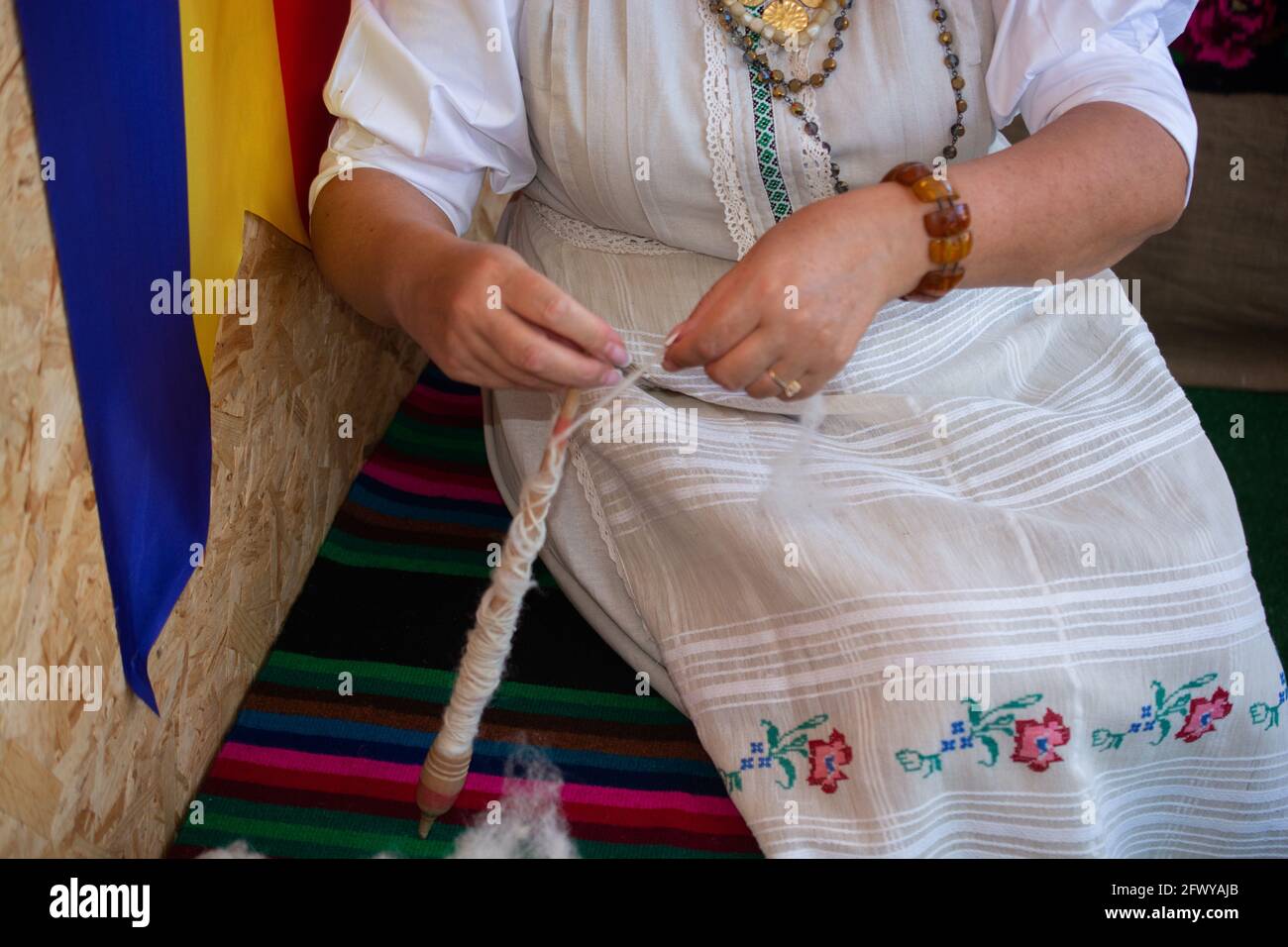 Spinner creates a thread of white wool. Creating yarn threads Stock ...