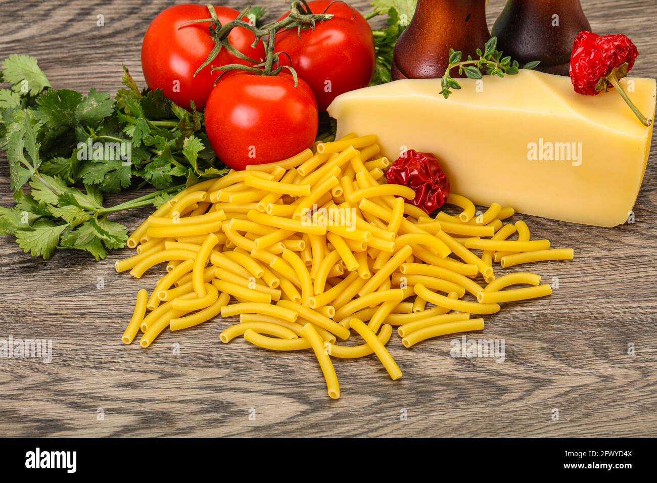 Italian pasta raw Maccheroni for cooking served vegetables Stock Photo ...