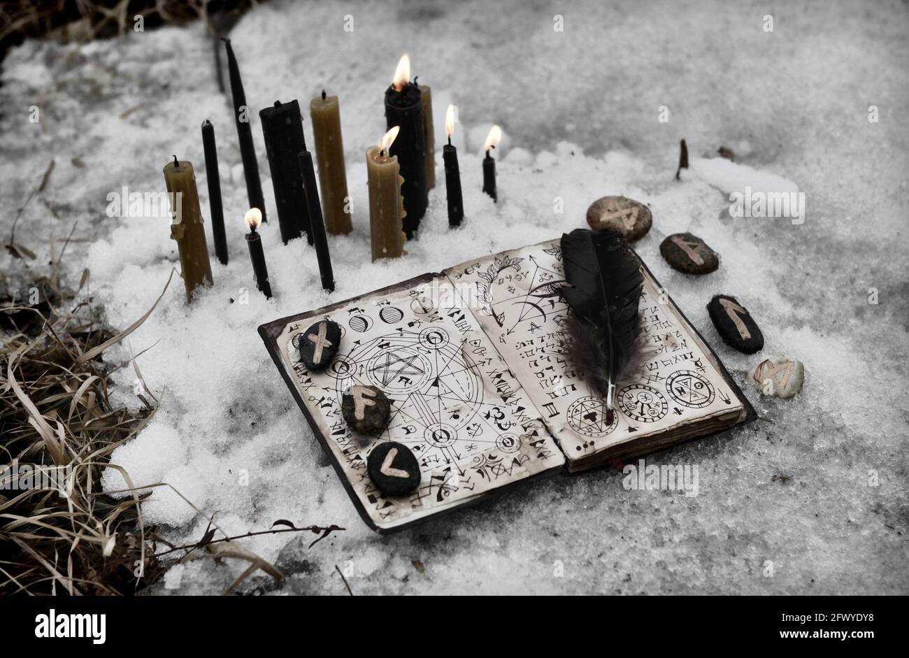 Grunge still life with open book of magic spells, runes and black ...
