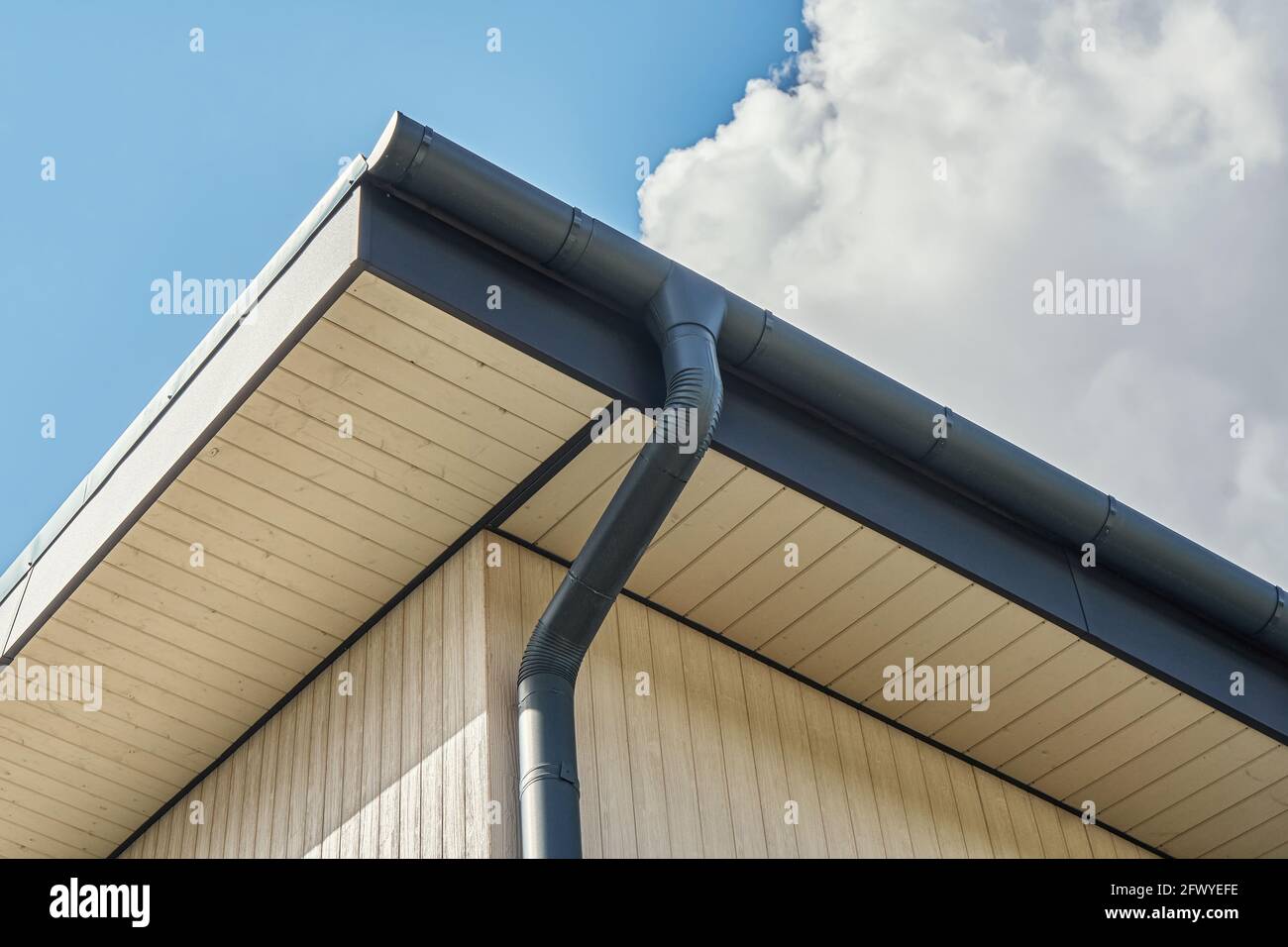 Contemporary grey metal rainwater downpipe installed on roof of new ...