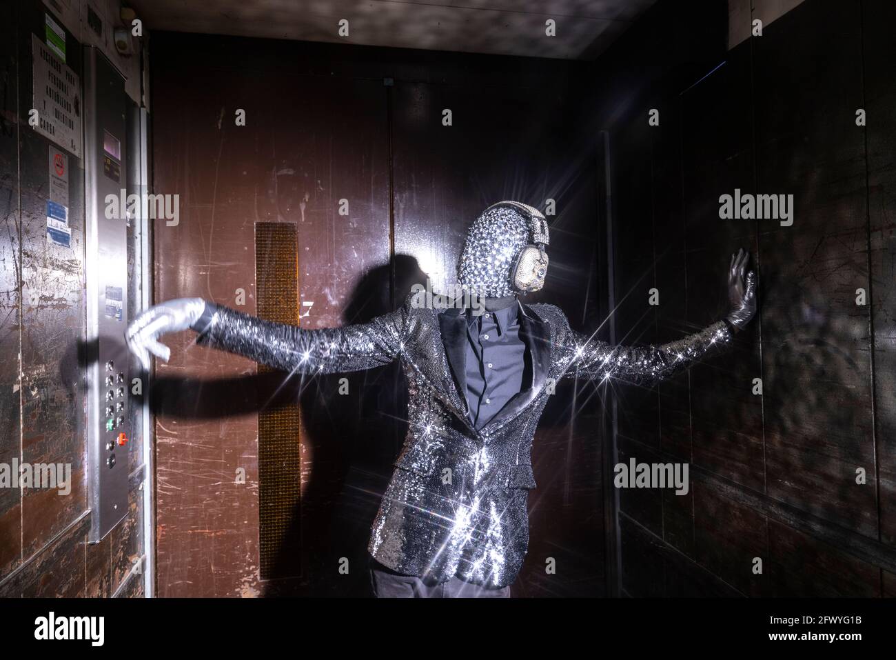 Sparkle masked man dancing in a lift Stock Photo - Alamy