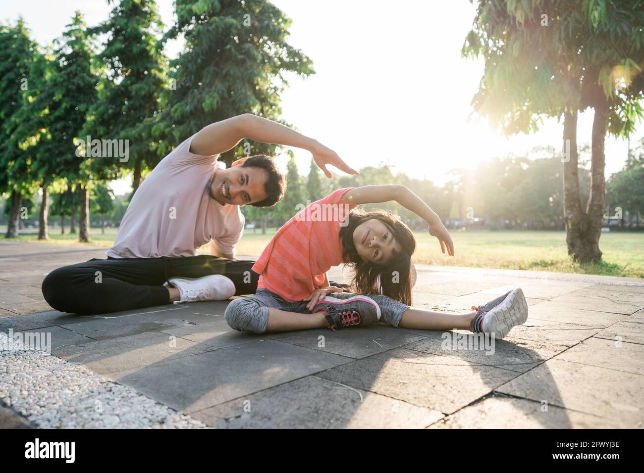 father and little daughter do exercises in outdoor. Healthy lifestyle ...