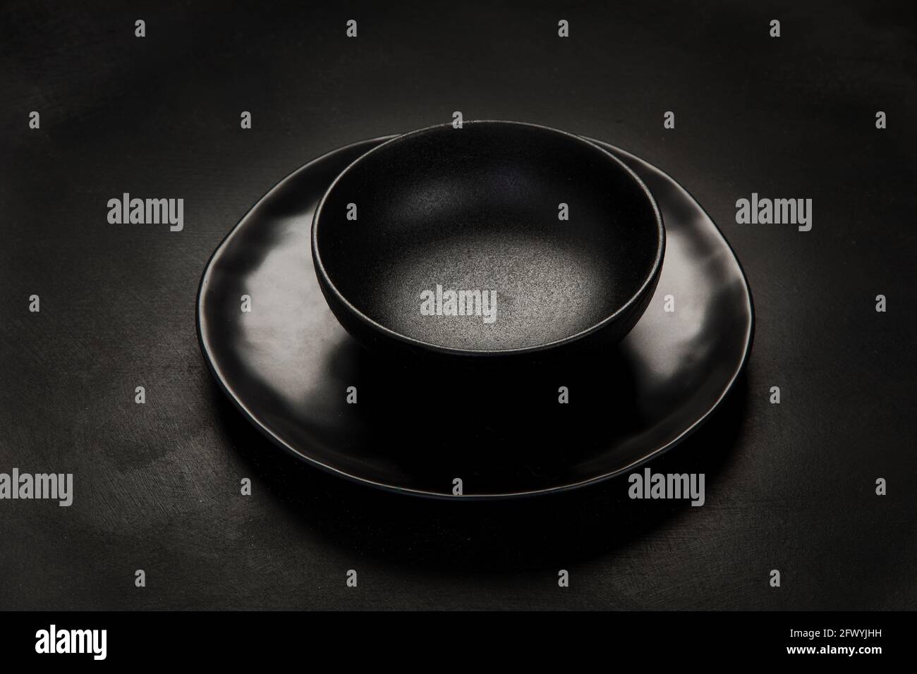 Table setting with a black plates on a black background. Minimalism ...
