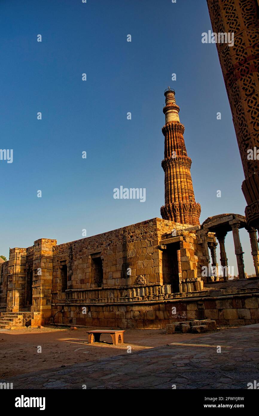 View of Qutub Minar surrounded by stone wall structure Stock Photo - Alamy