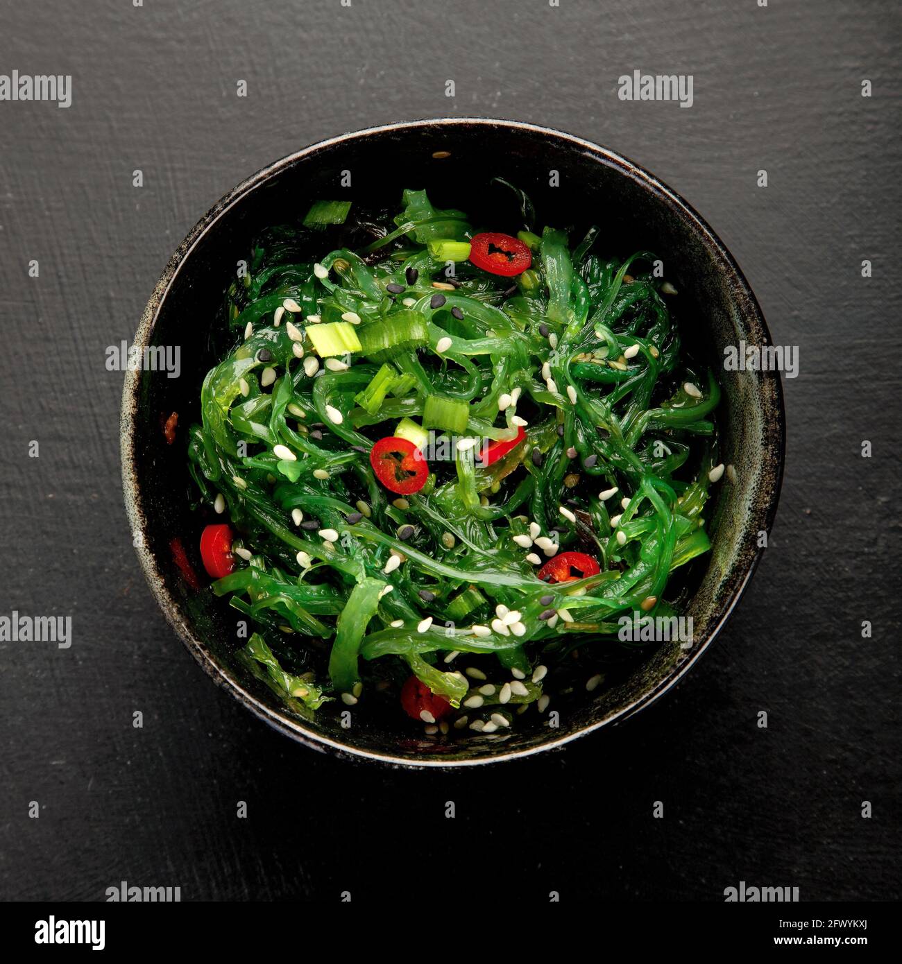 Wakame seaweed with sesame and chilli on gray background. Asian food ...